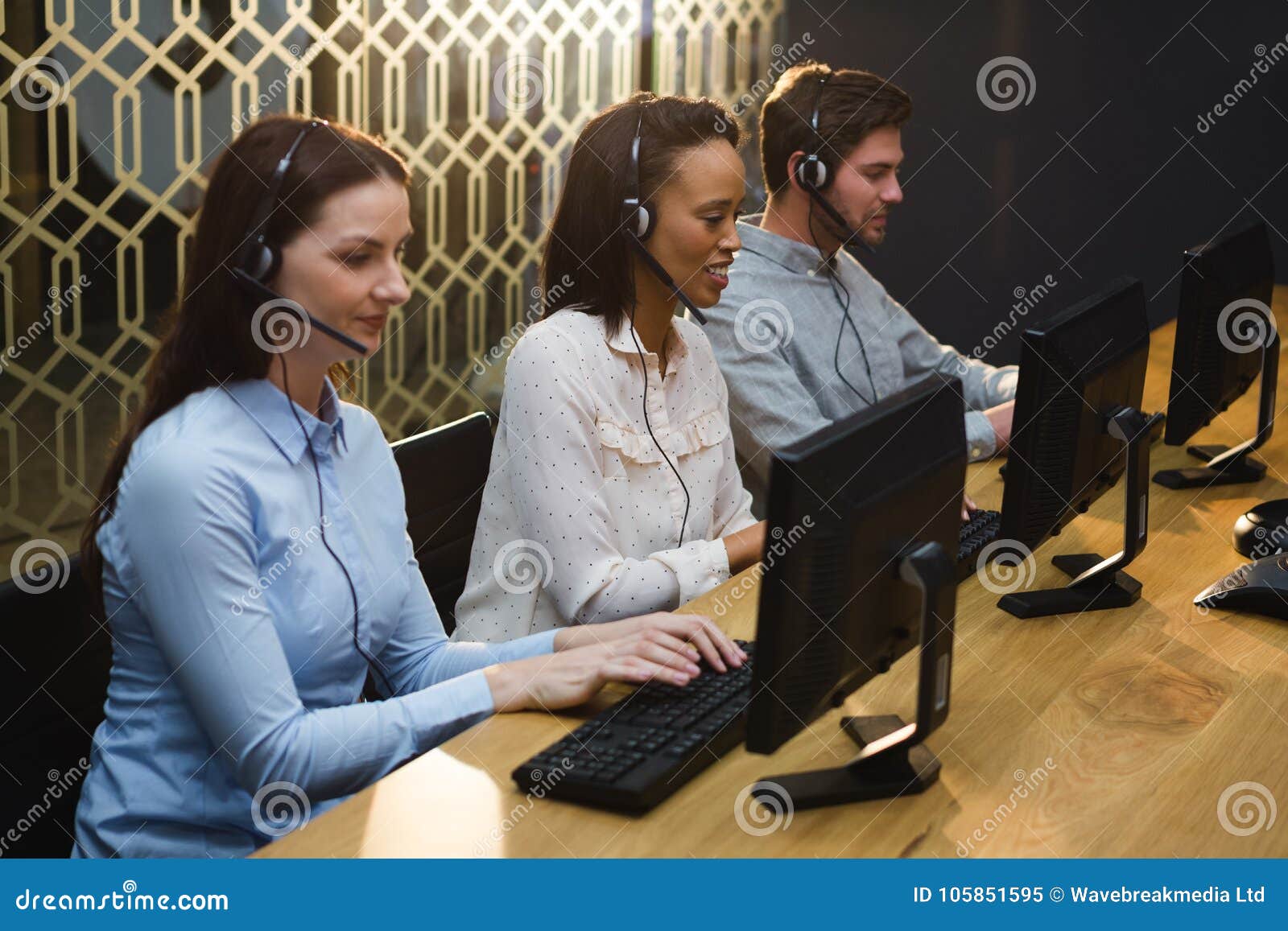 Business Executives with Headsets Using Computers at Desk Stock Image ...