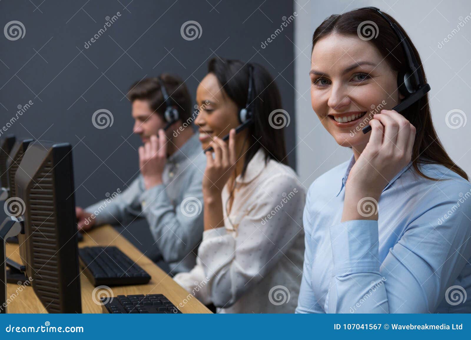 Business Executives with Headsets Using Computers at Desk Stock Image ...