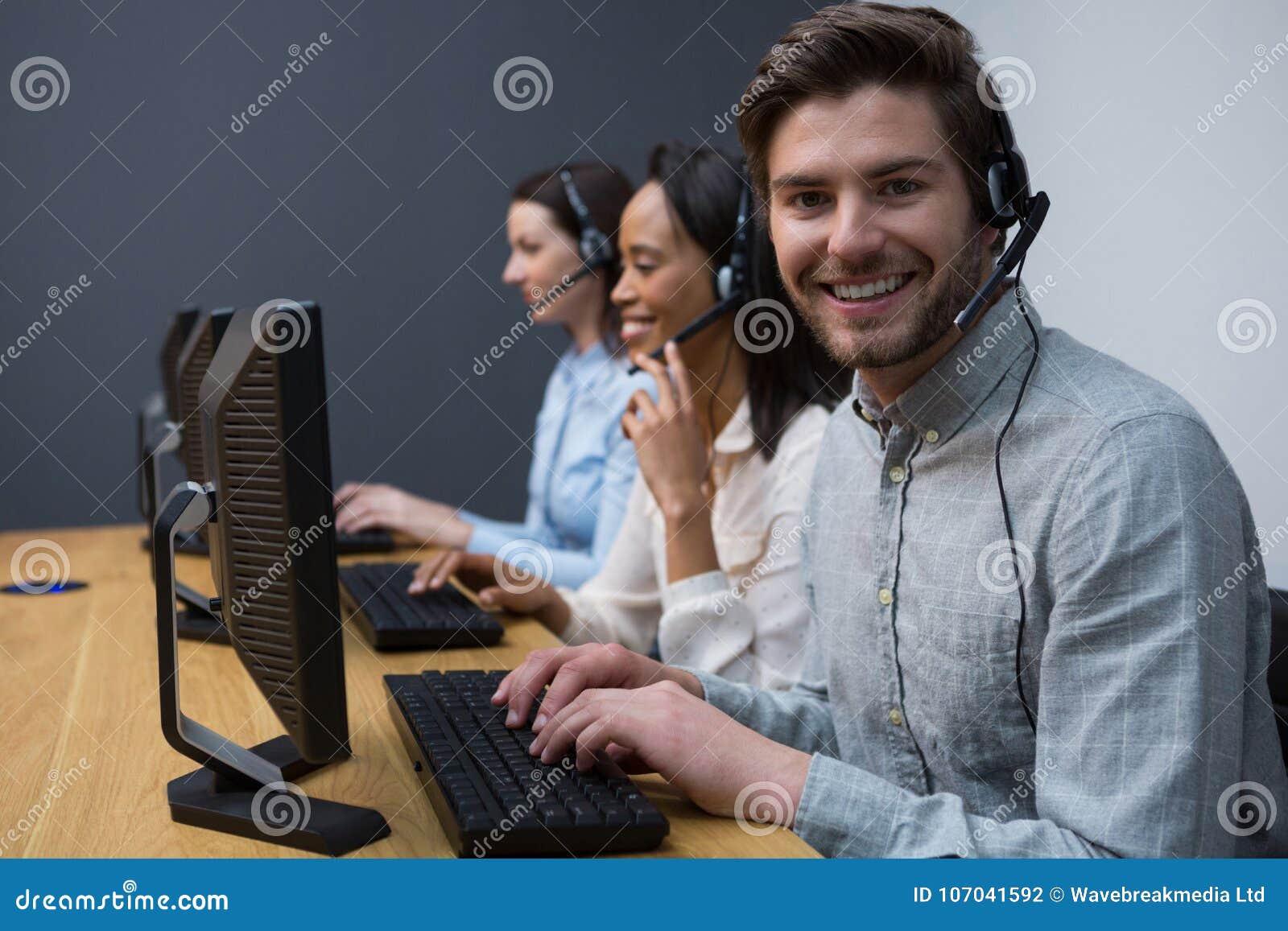 Business Executives with Headsets Using Computers at Desk Stock Photo ...