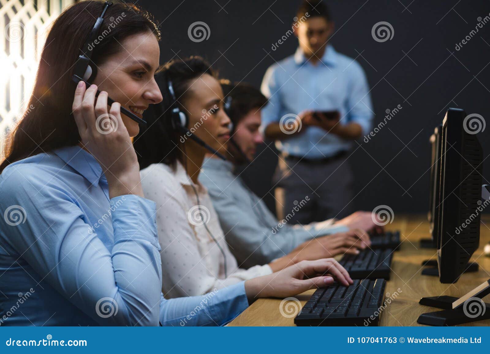 Business Executives with Headsets Using Computers at Desk Stock Image ...