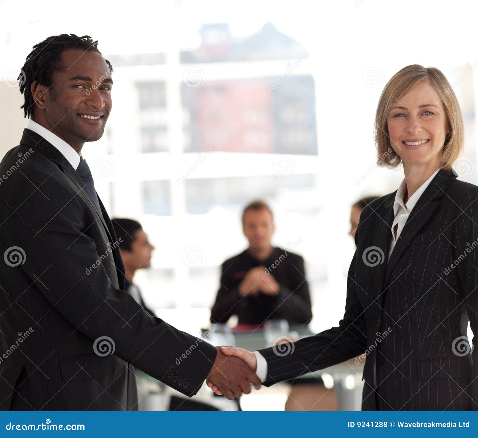 Business Handshake in Front of Workgroup Stock Photo - Image of hand ...