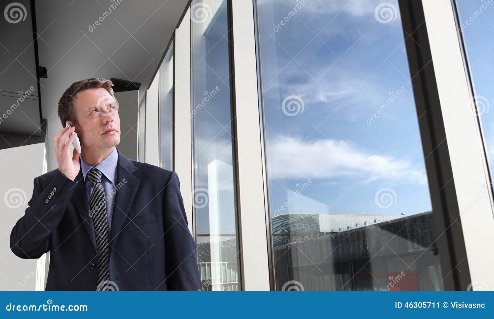 Business Man in Office Talking on the Phone and Looks through the ...