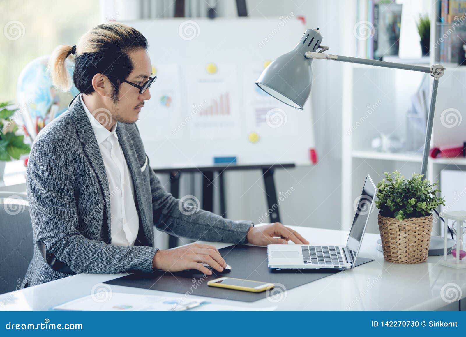 Business Man in Office Using Laptop and Cell Phone Stock Photo - Image ...