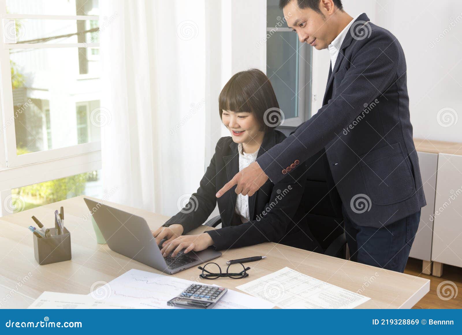 Business Man Pointing Finger at Computer while Woman Worker Working and ...