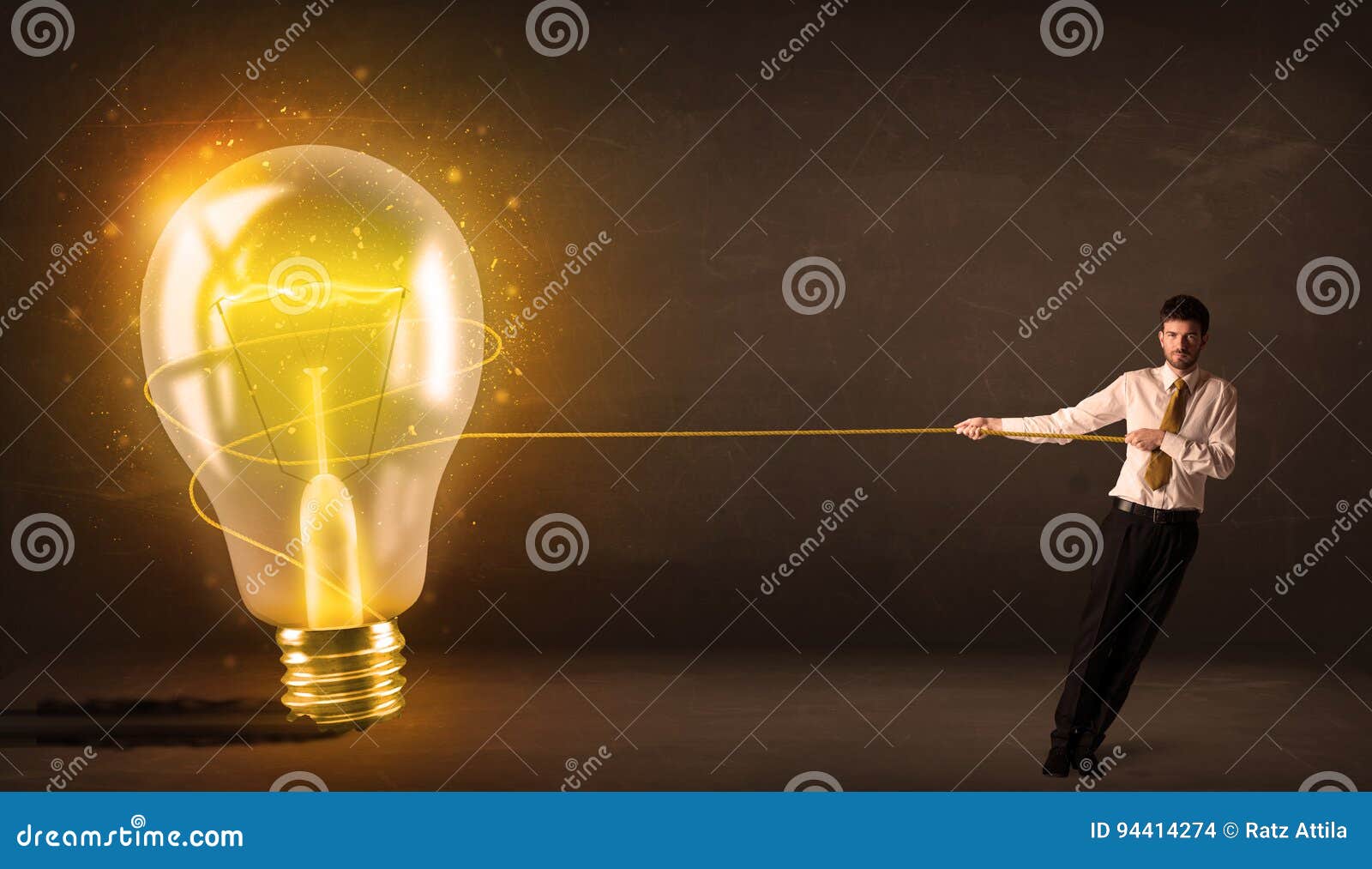 Business Man Pulling a Big Bright Glowing Light Bulb Stock Photo ...