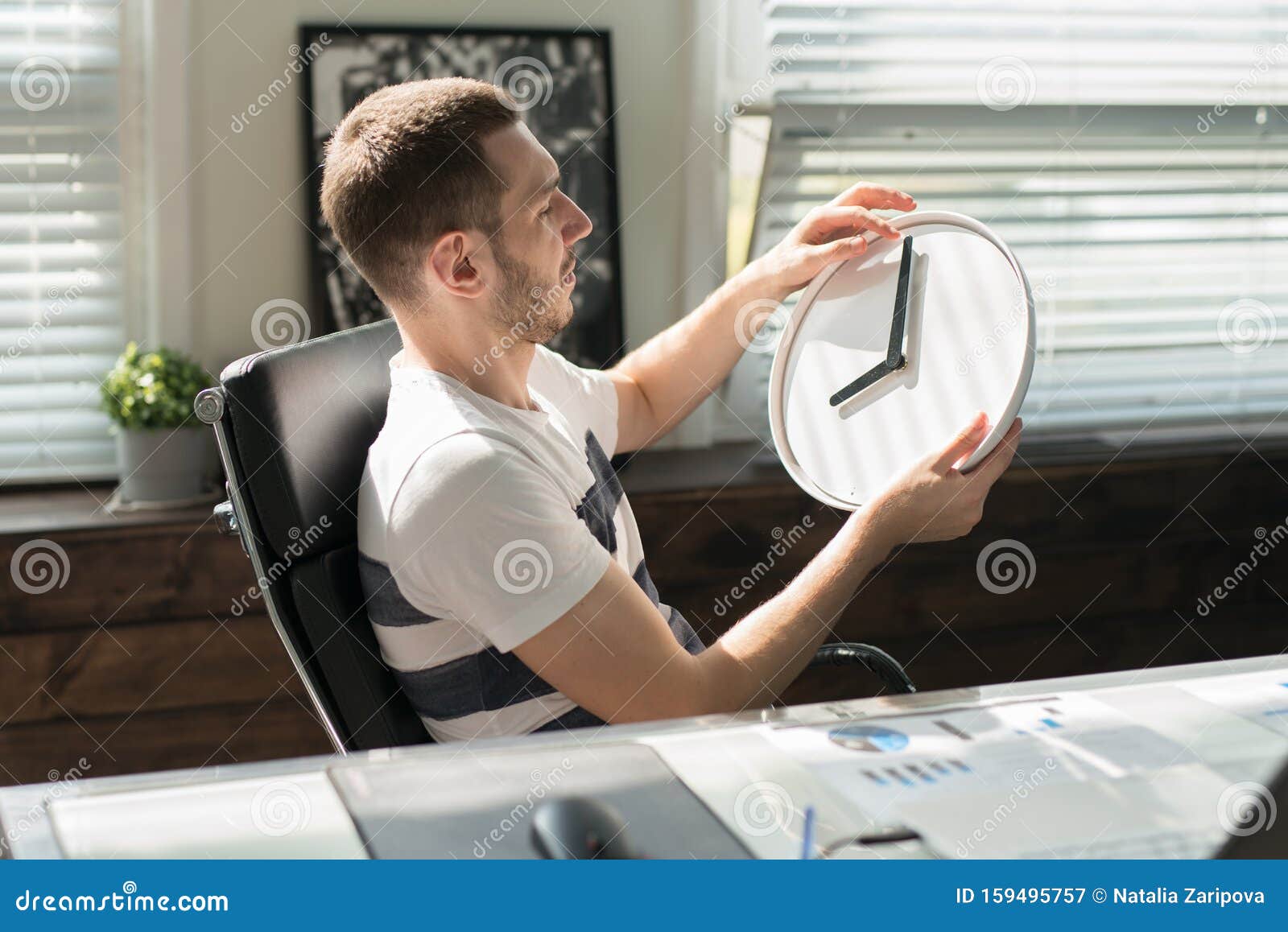 Business Man Sits at a Desk, Holds a Clock Stock Image - Image of ...