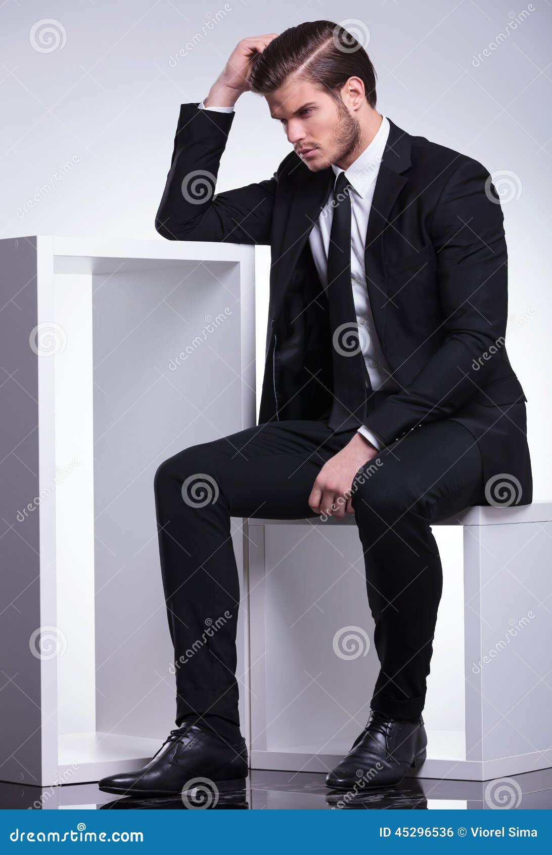 Business Man Sitting on a Table while Scratching His Head Stock Photo ...
