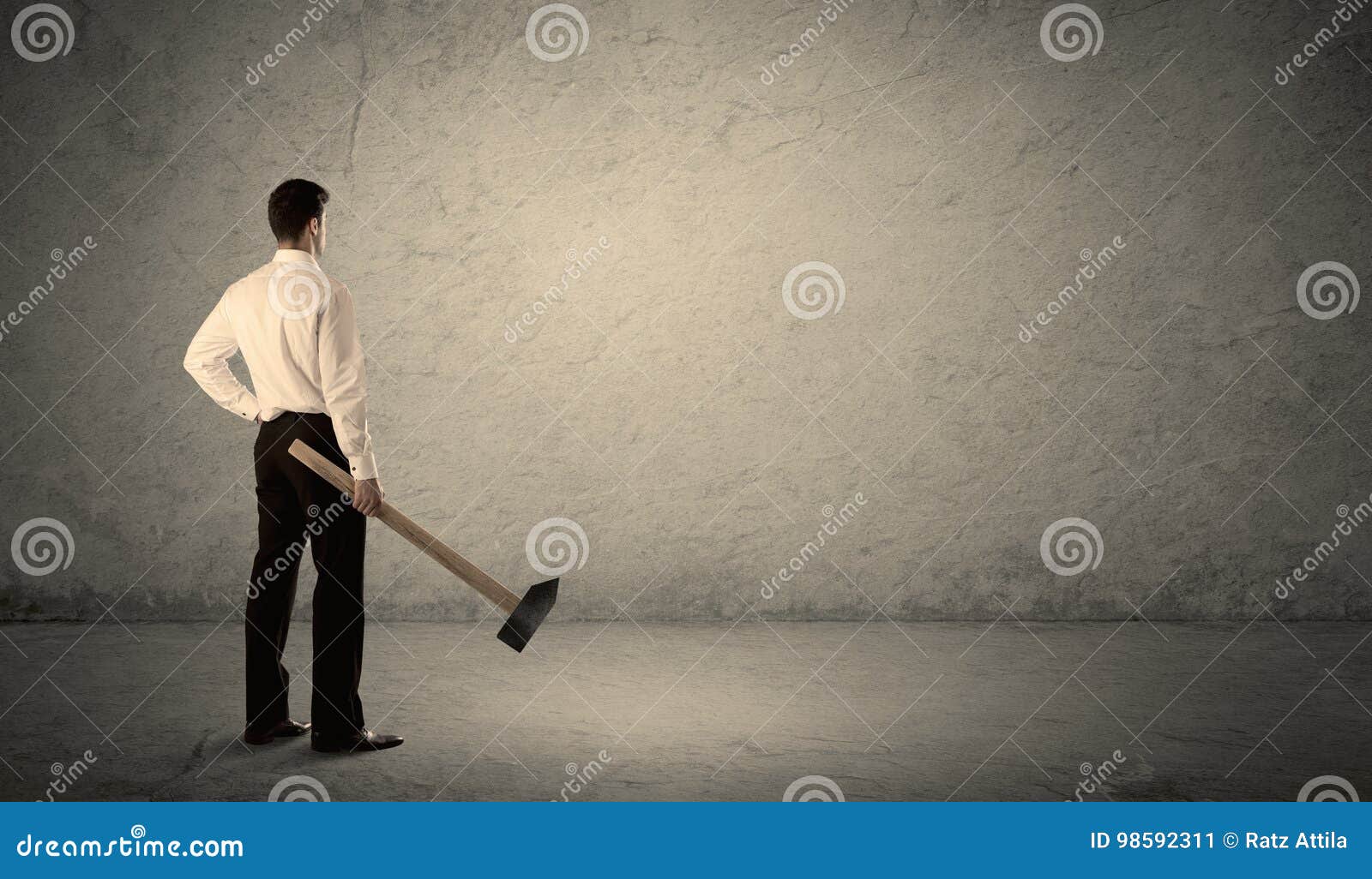 Business Man Standing in Front of a Grungy Wall with a Hammer Stock ...