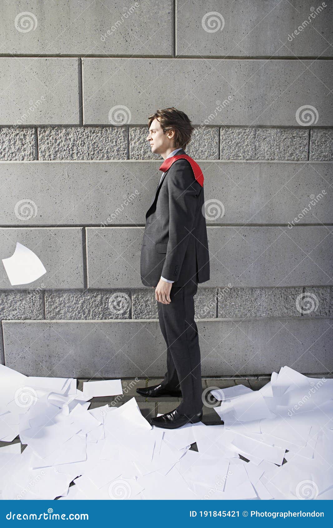Business Man Surrounded by Paper Material beside Wall Stock Image ...