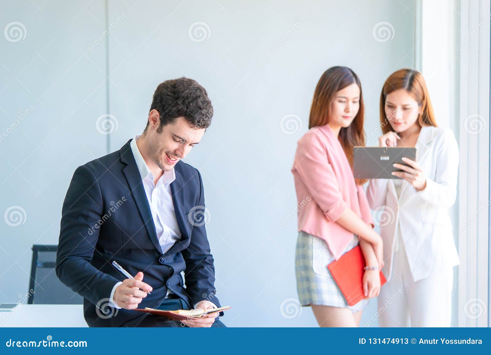 Business Man Taking Note in Front of Two Female Office Worker Stock ...