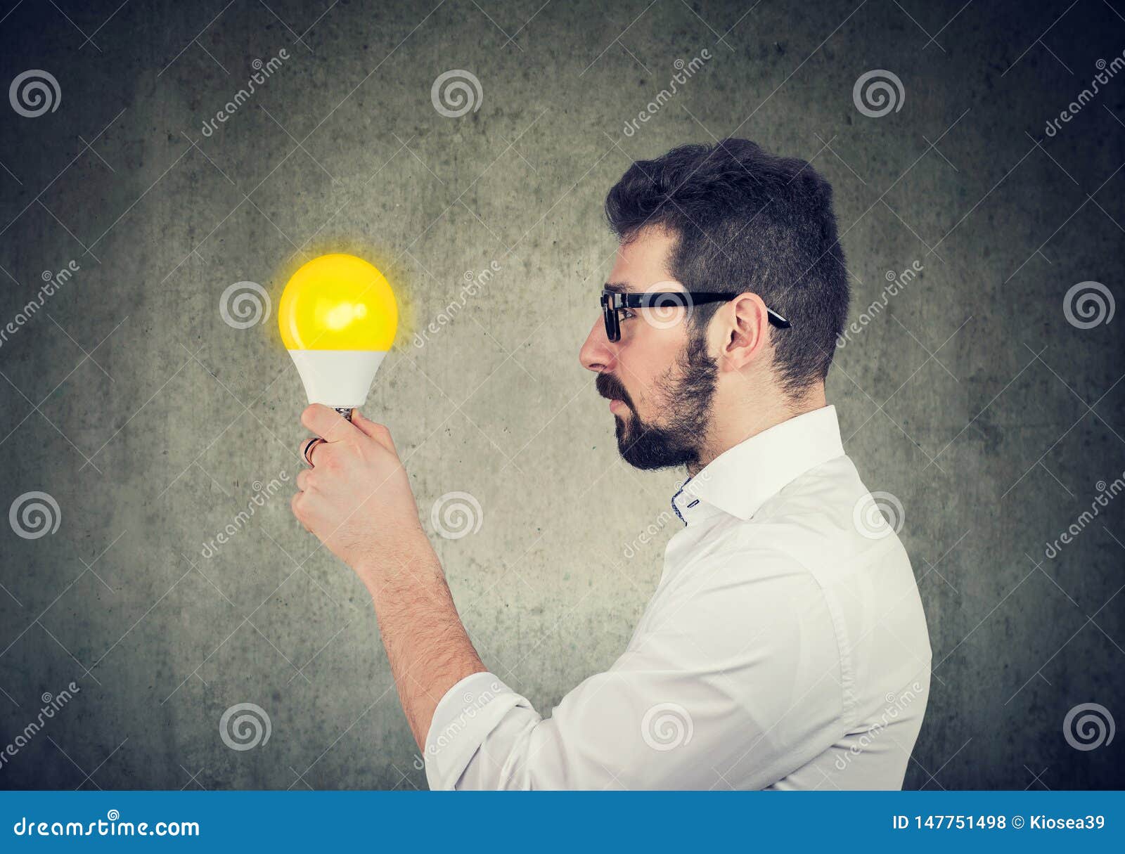 Business Man with Thoughtful Expression Looking at Bright Light Bulb ...
