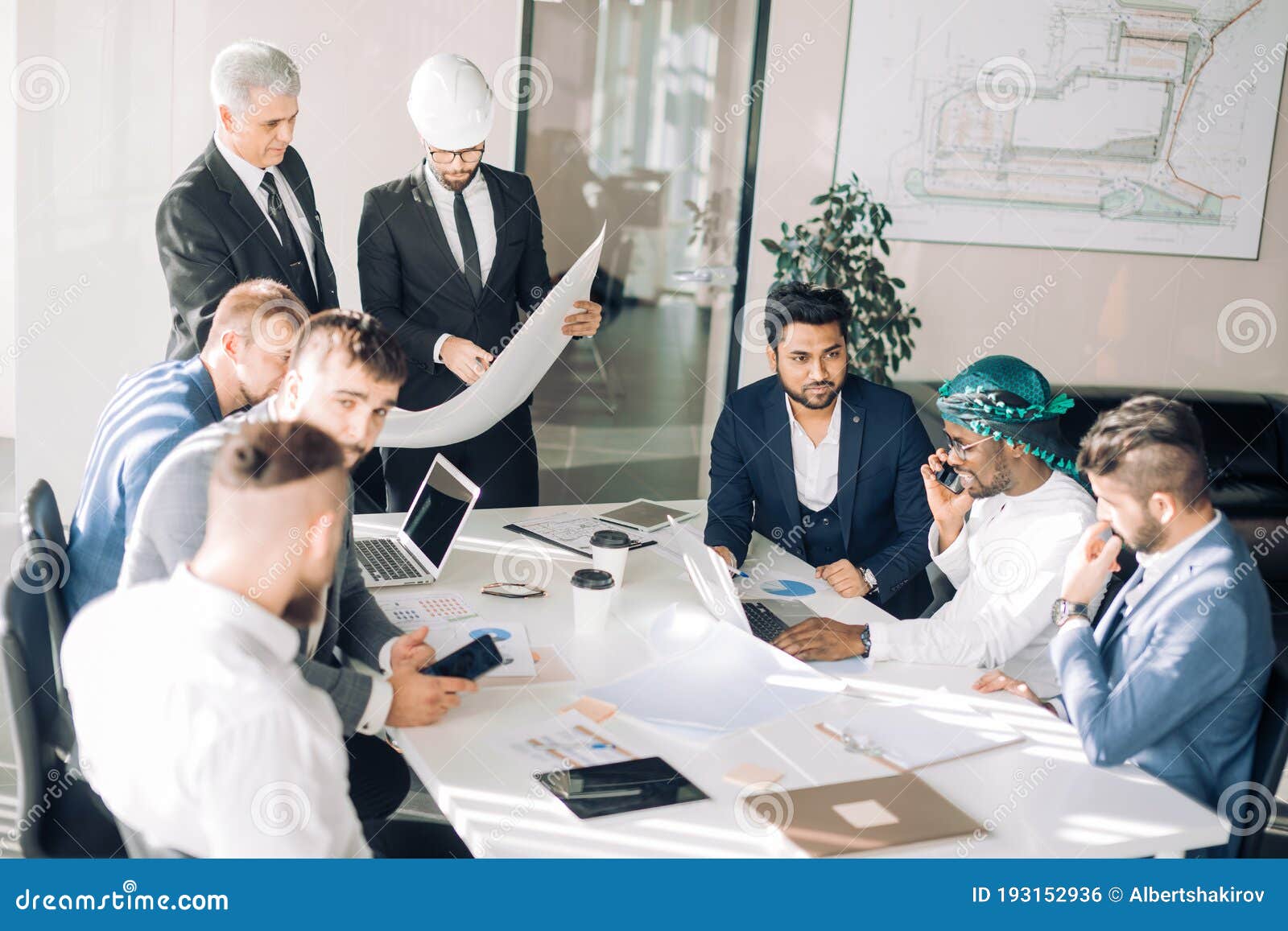 Multiracial Group of Constructors and Architects Discussing Blueprint ...
