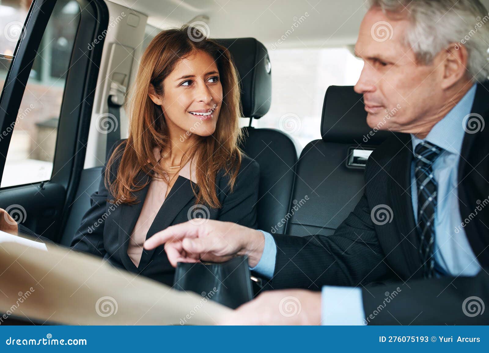 Business in Motion. Colleagues Going through Paperwork in the Back Seat ...