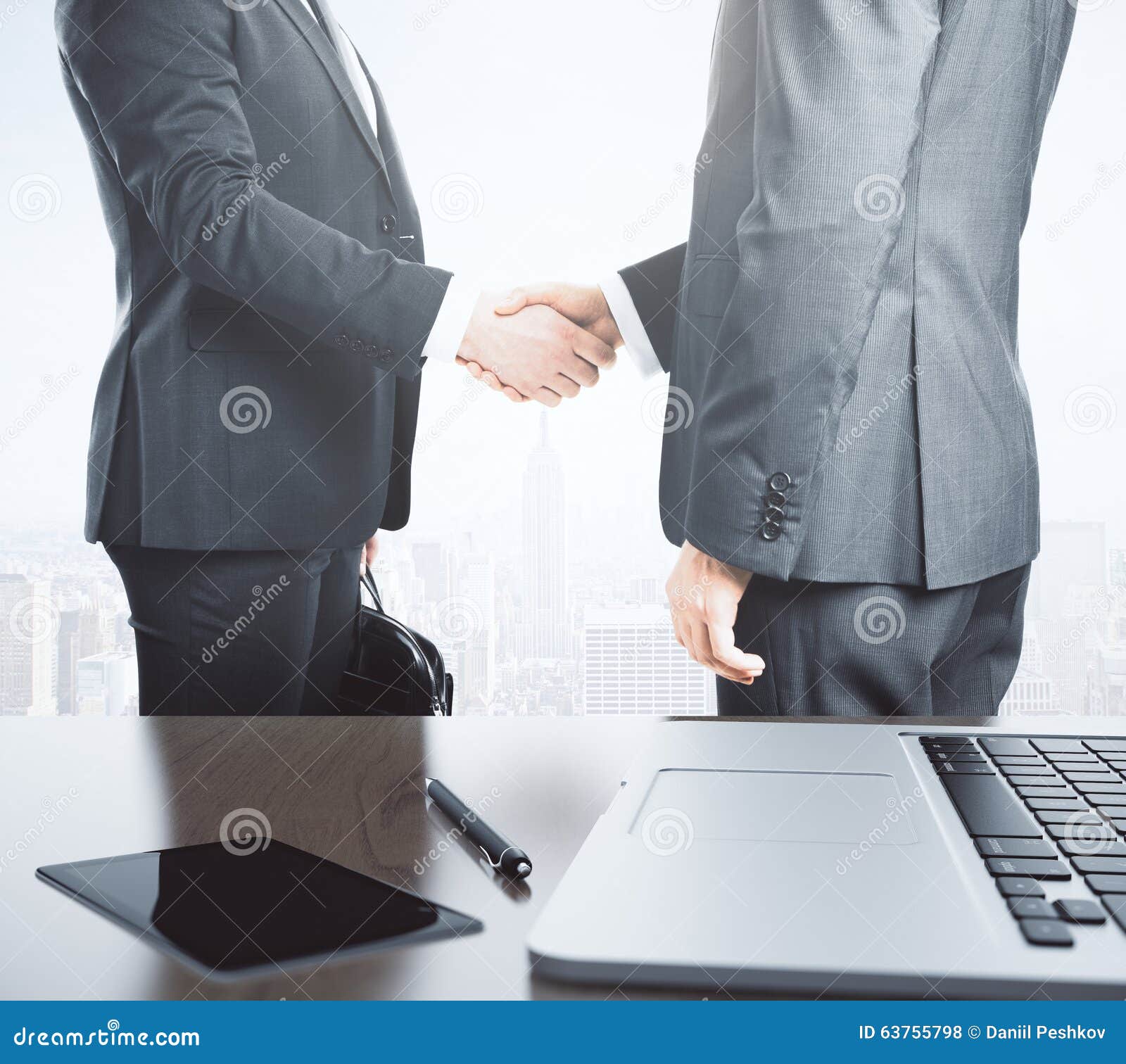 Business Partners Shake Hands and Table with Laptop and Diary Stock ...