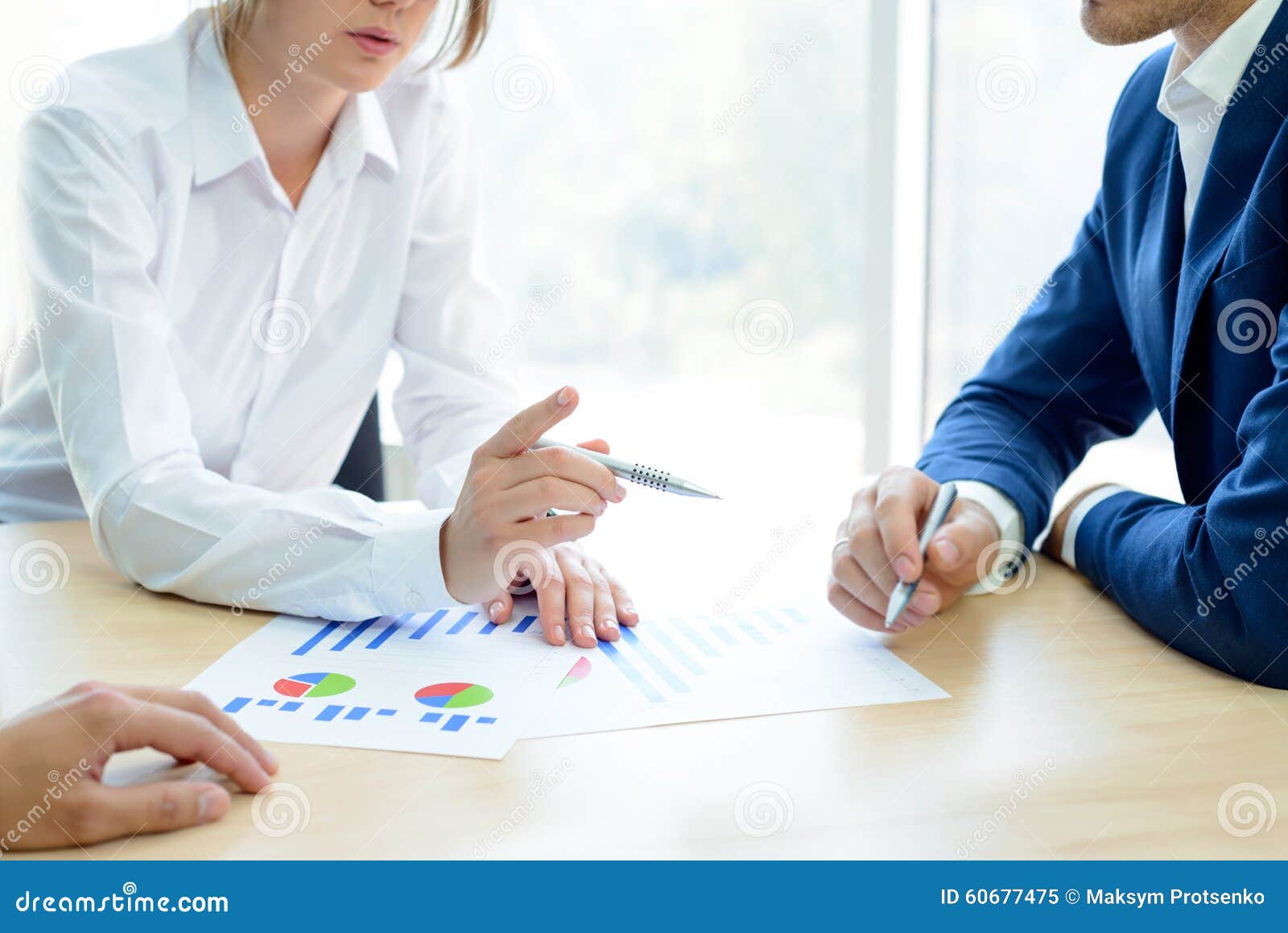 Business People Analyzing Financial Results on Graphs Around the Table ...