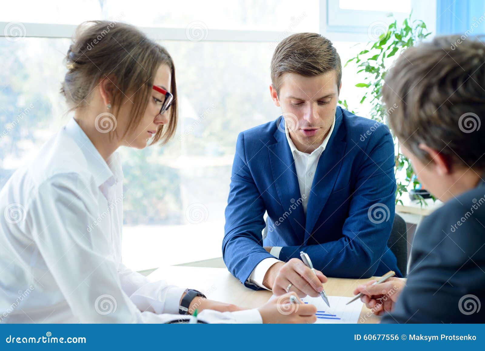 Business People Analyzing Financial Results on Graphs Around the Table ...