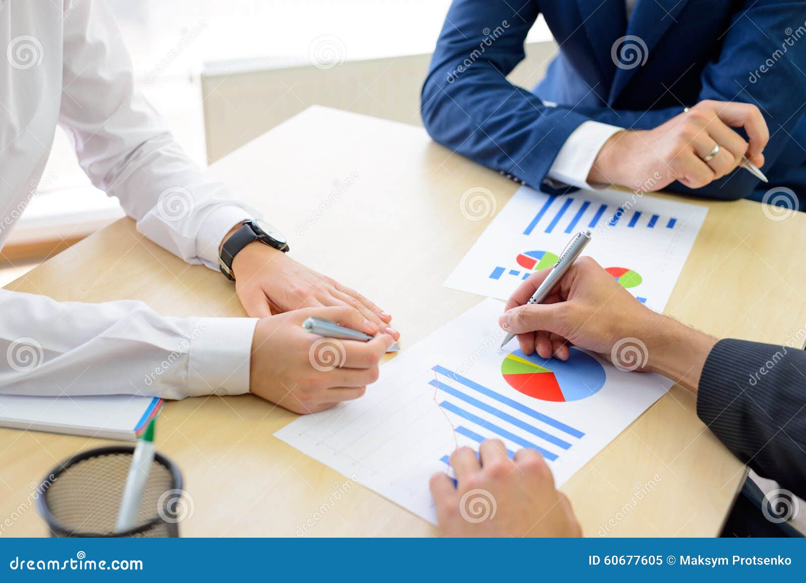 Business People Analyzing Financial Results on Graphs Around the Table ...