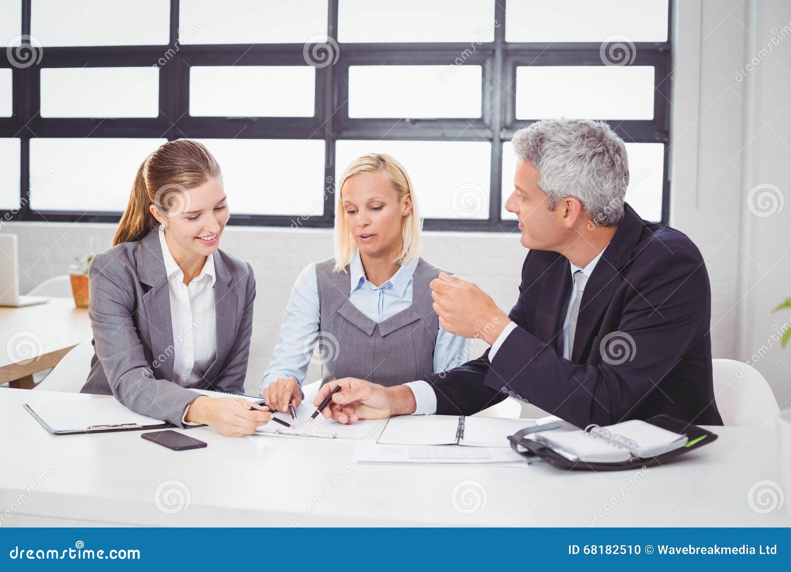 Business People Discussing with Client Over Documents Stock Photo ...