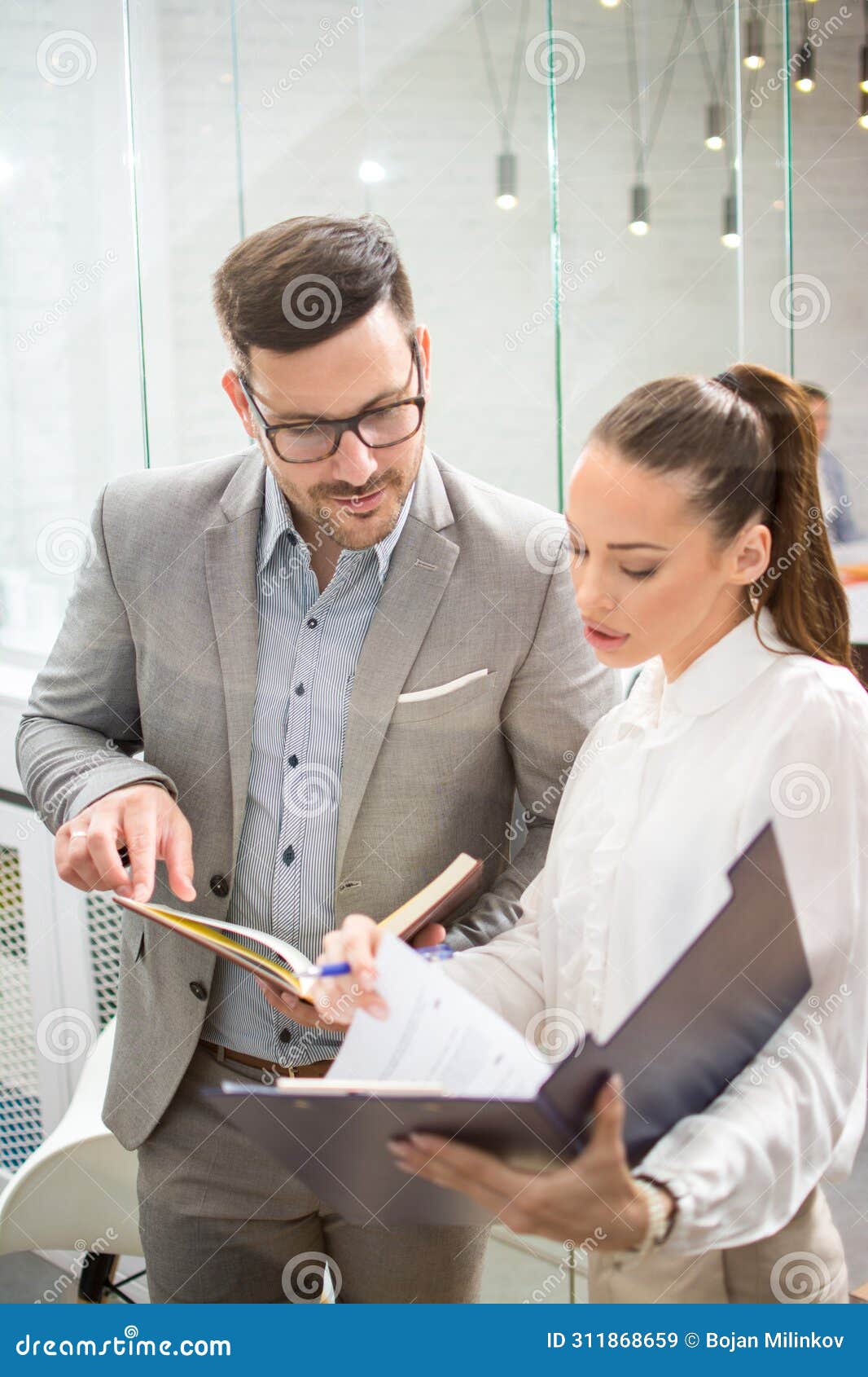 Business People Discussing Document in Office Lobby. Stock Image ...