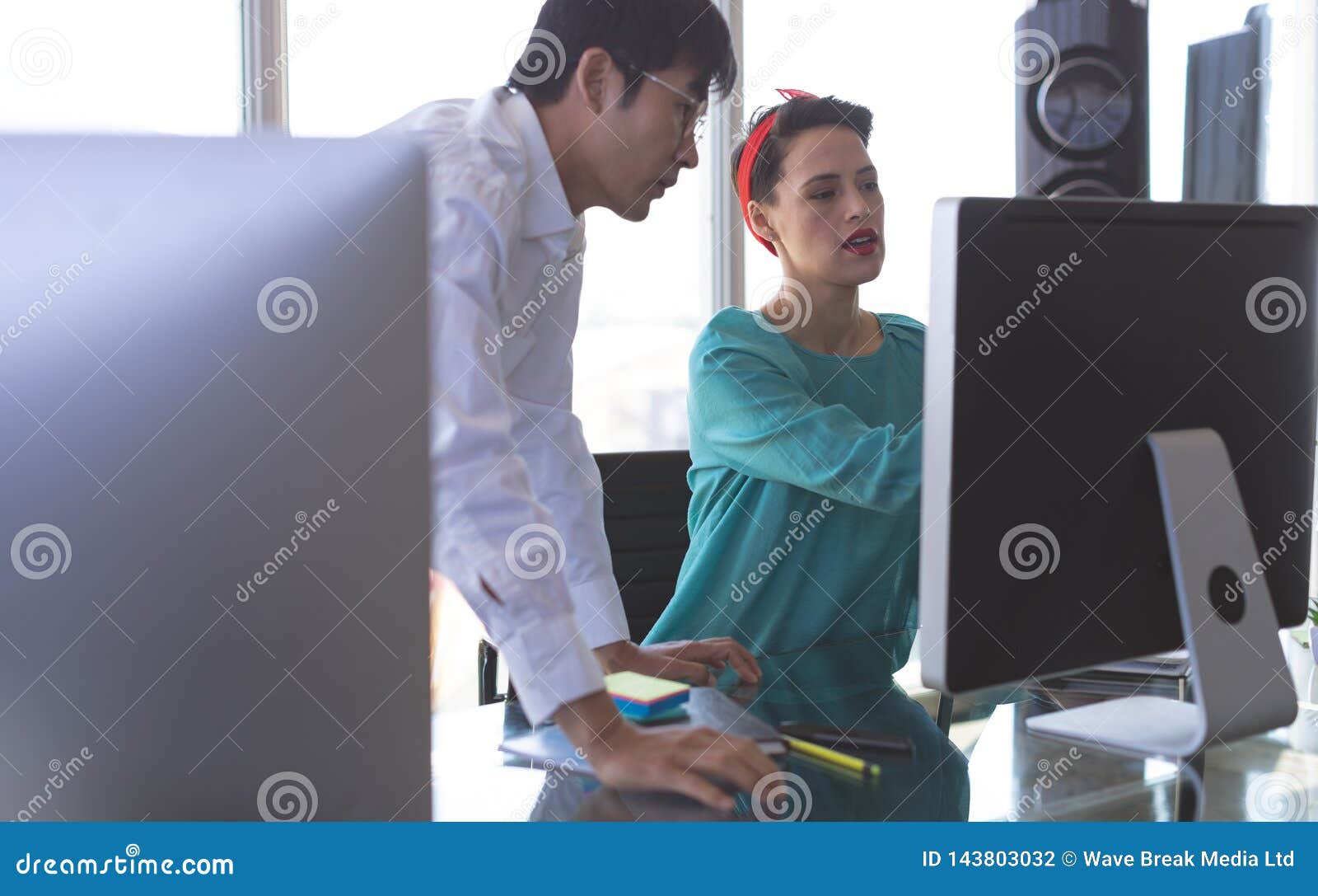 Business People Discussing Over Computer at Desk in Office Stock Photo ...