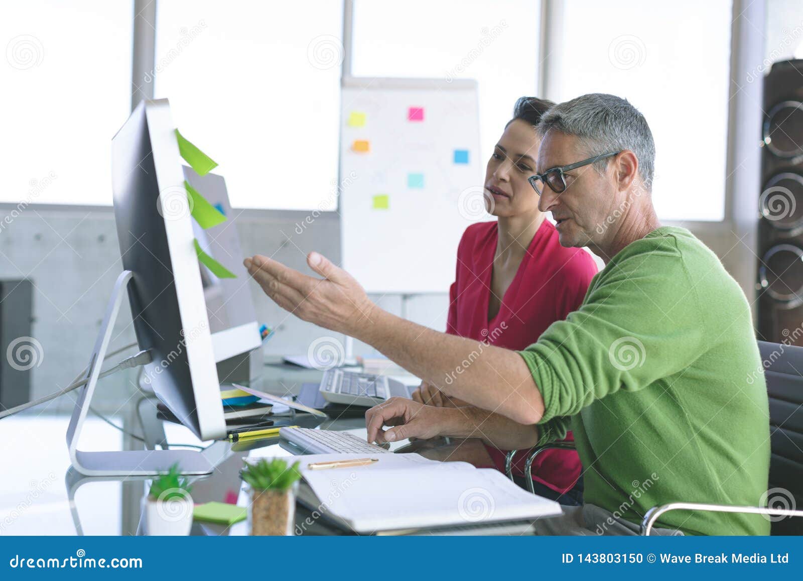 Business People Discussing Over Computer at Desk in Office Stock Photo ...