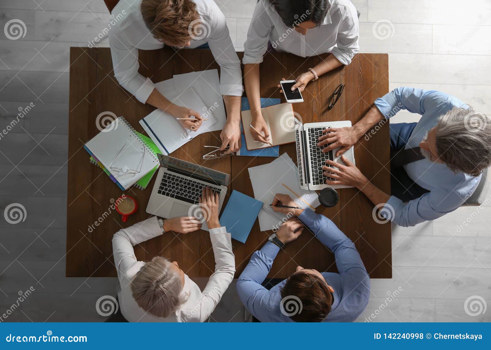 Business People Discussing Work Matters at Table in Office, Top View ... Business People Discussing Work Matters at Table in Office, Top View ...