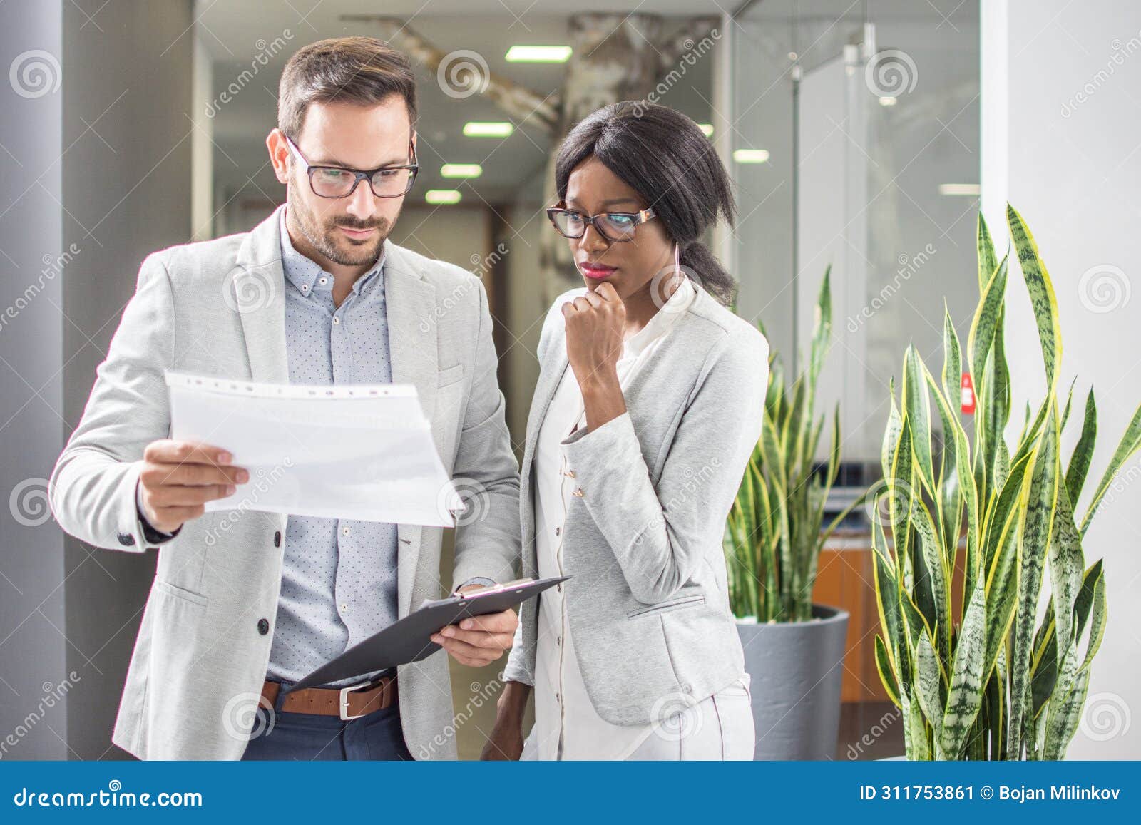 Business People in Formal Wear Reading Document in Office Hall. Stock ...