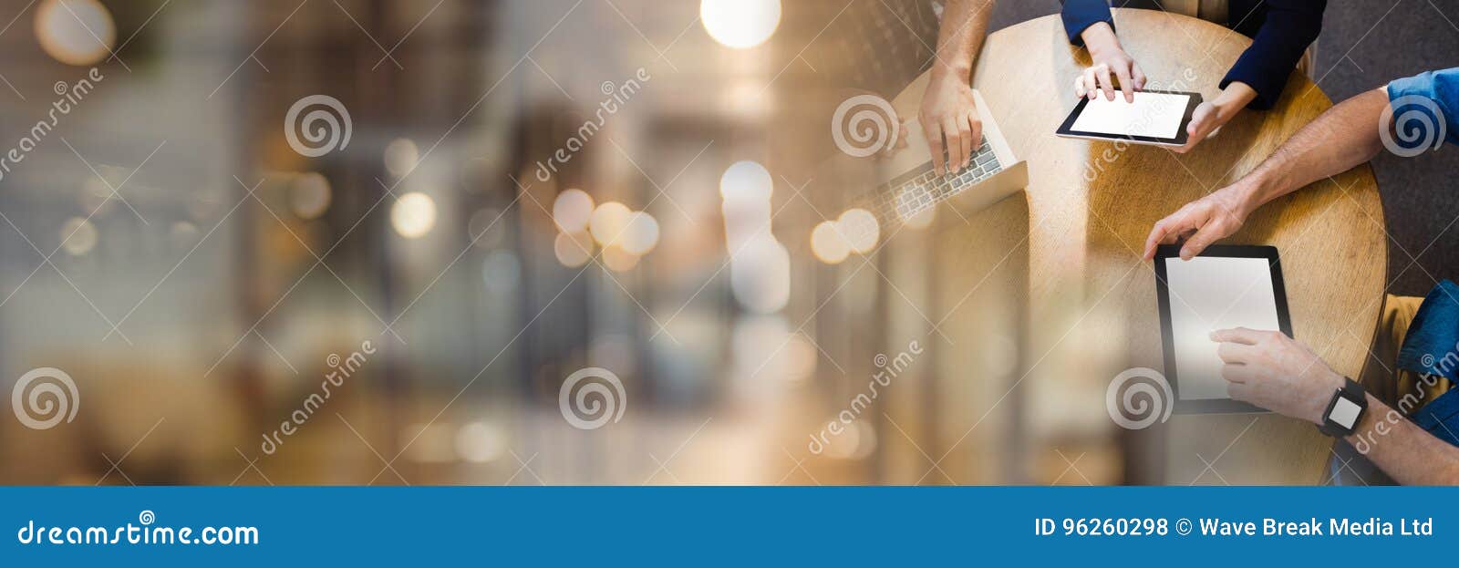 Business People Holding Tablets Having a Meeting with Blurred Lights ...
