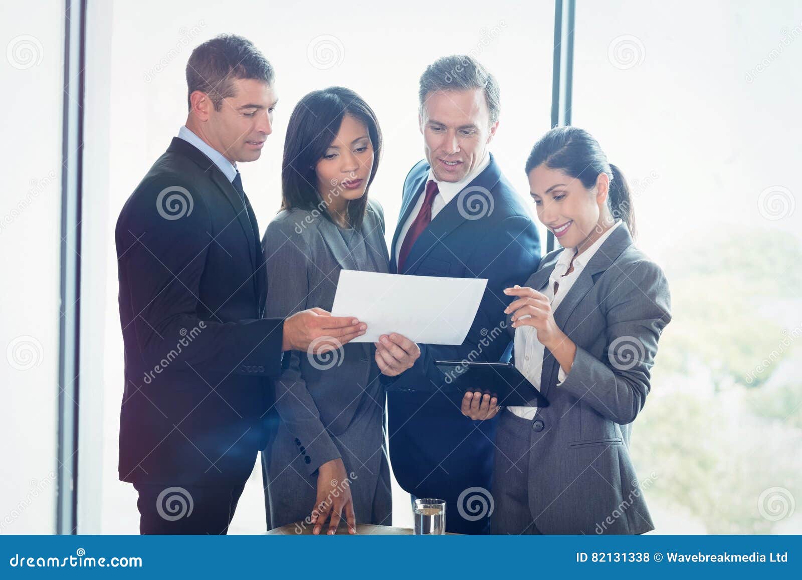 Business People Looking at Document while Standing Stock Photo - Image ...