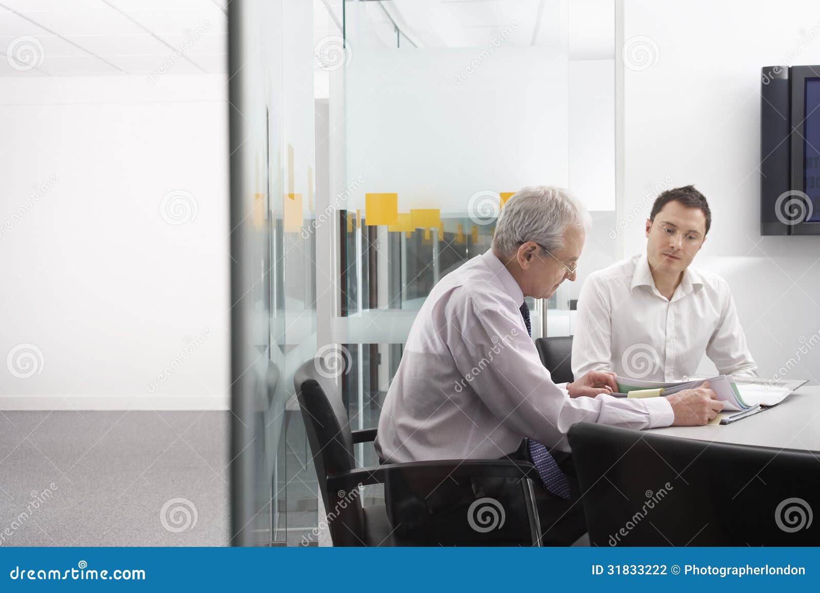 Business People Reviewing Documents at Table Stock Photo - Image of ...