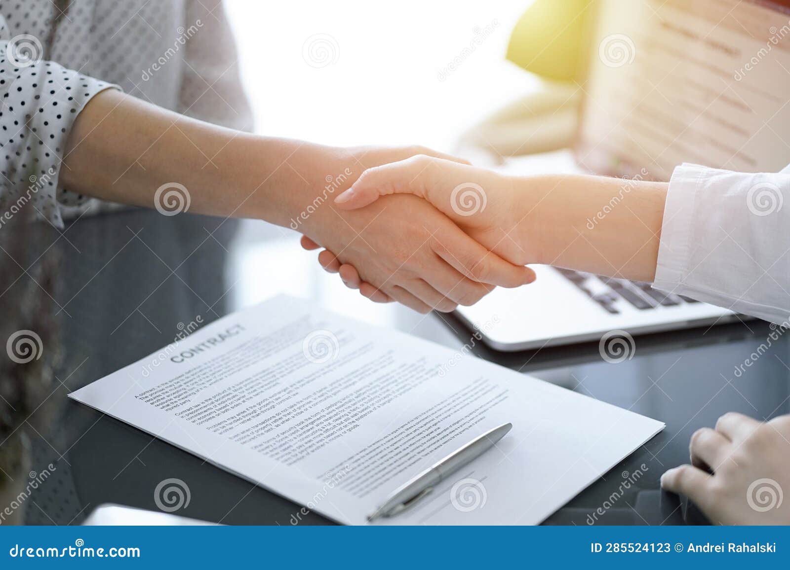 Business People Shaking Hands Above Contract Papers in Office Stock ...