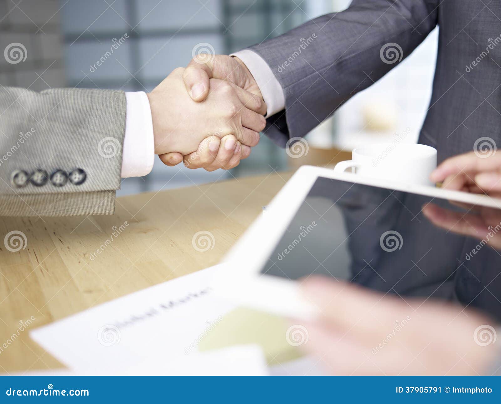 Two People Shaking Hands And Exchanging Documents As A Sign Of ...