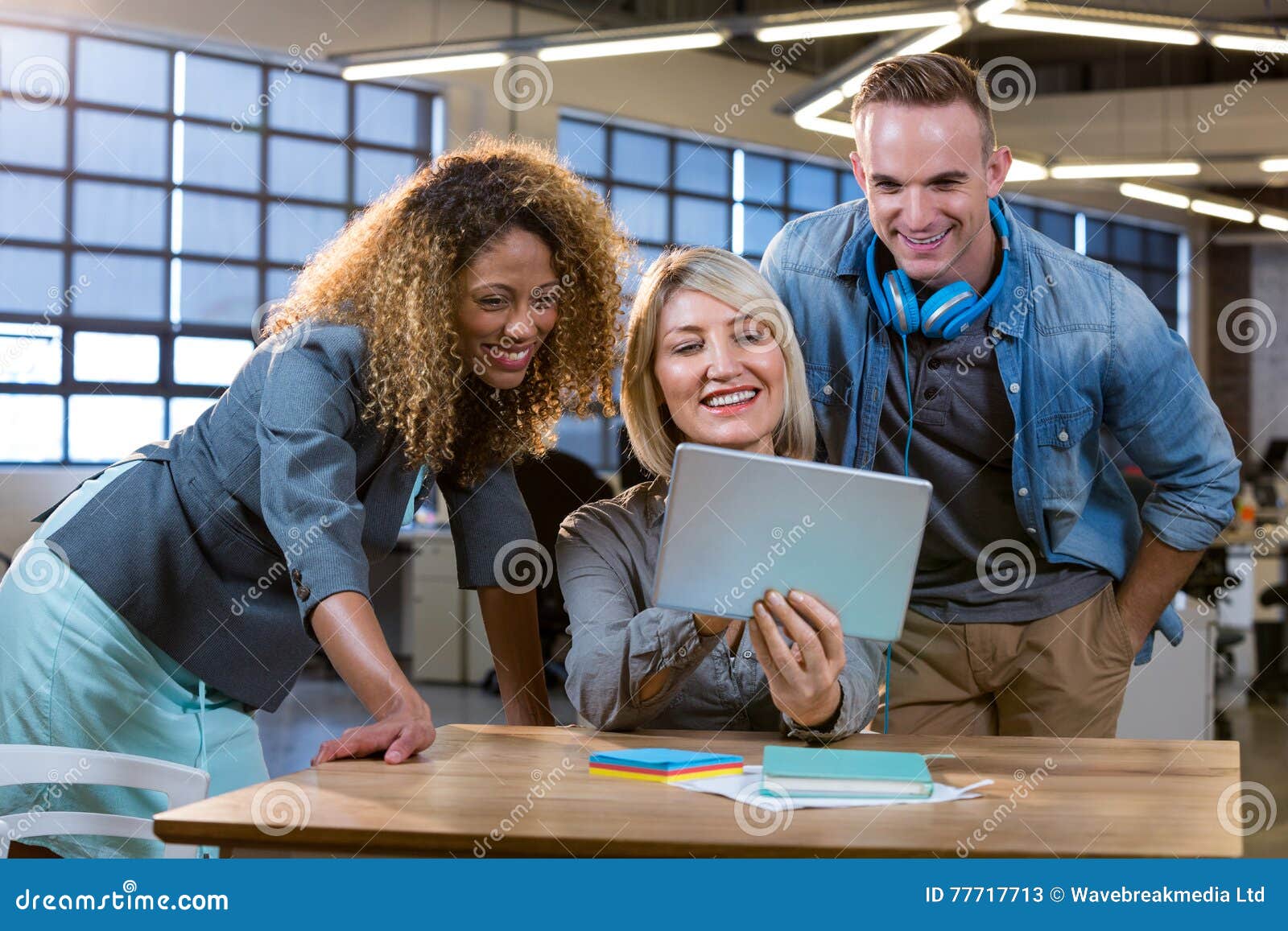 Business People Smiling while Discussing Over Tablet Computer Stock ...