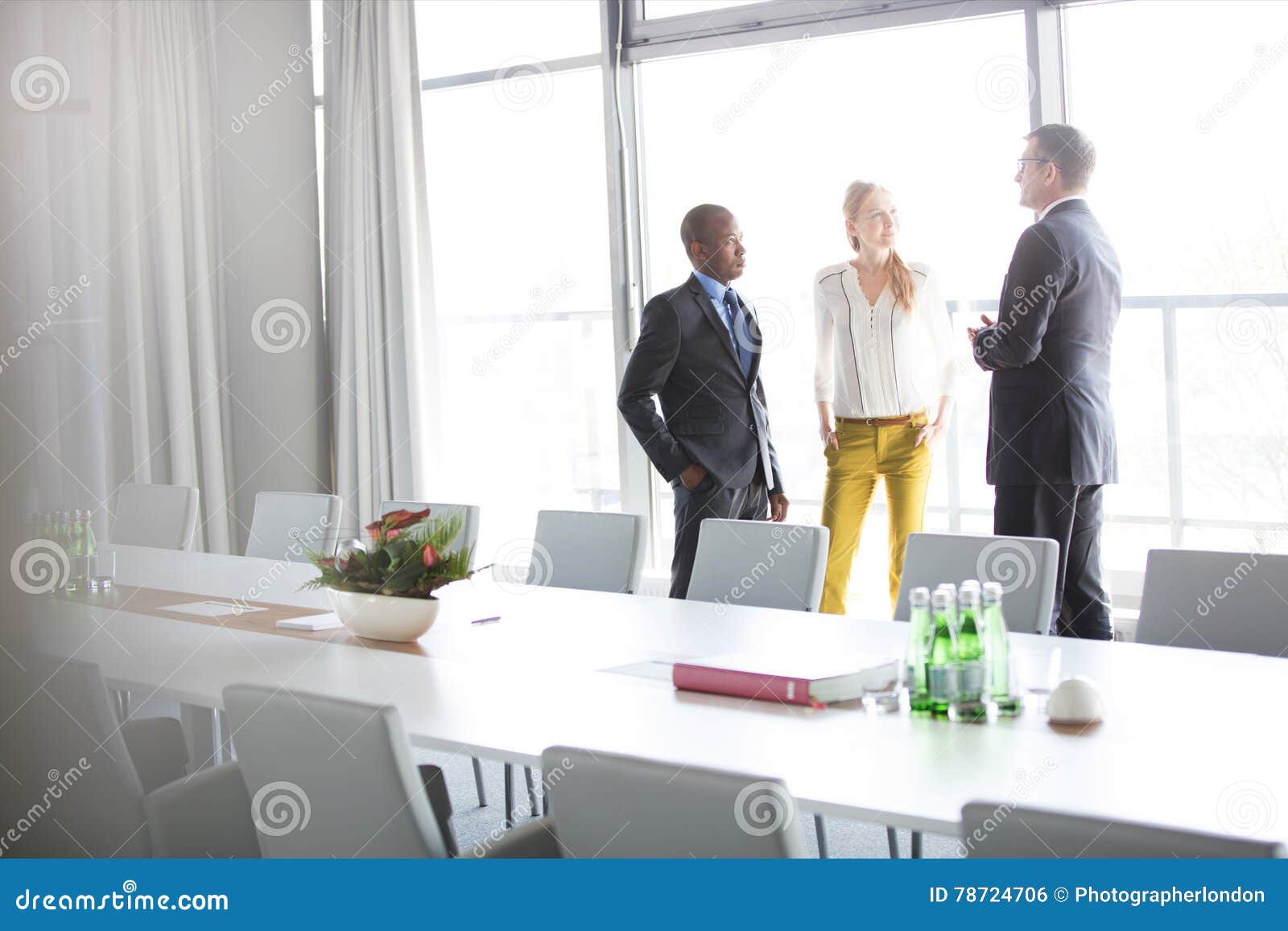Business People Talking while Standing by Conference Table in Office ...