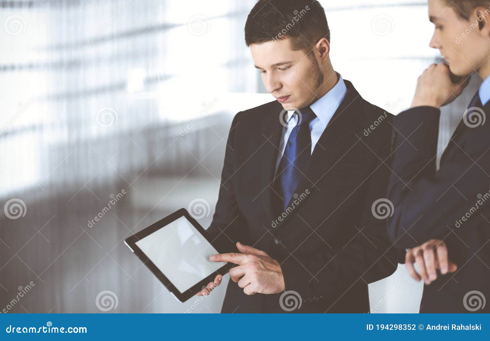 Business People are Using a Tablet Computer, while Standing in a Modern ...