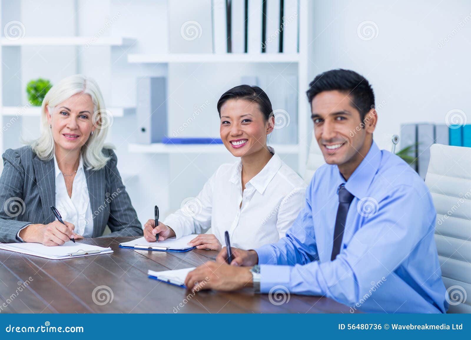 Business People Writing on Clipboards and Looking at Camera Stock Photo ...