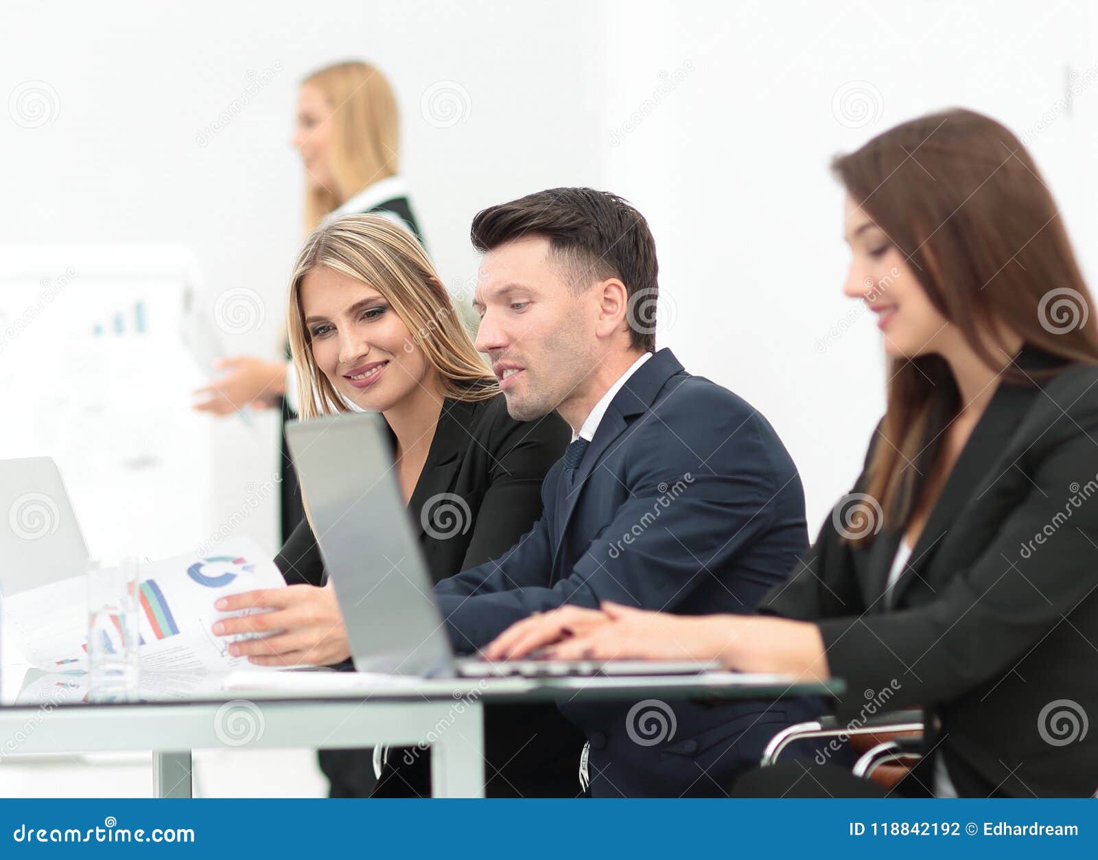Business Team Discussing New Information , Standing in Front of the ... Business Team Discussing New Information , Standing in Front of the ...