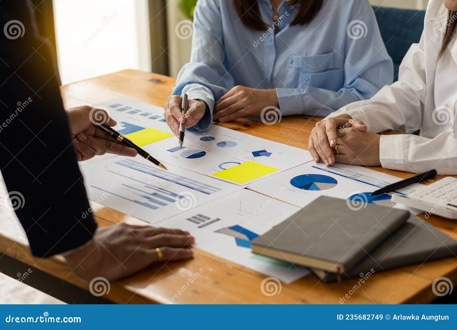 Business Team Discussing and Planning Projects Using Charts, Holding ...