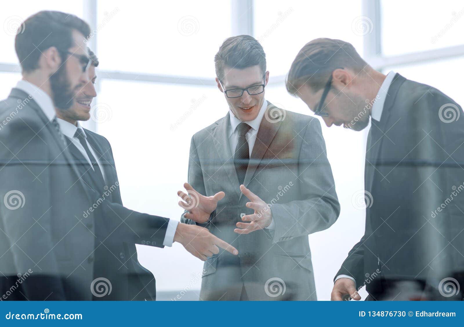 Business Team is Discussing Something Standing in the Office Stock ... Business Team is Discussing Something Standing in the Office Stock ...