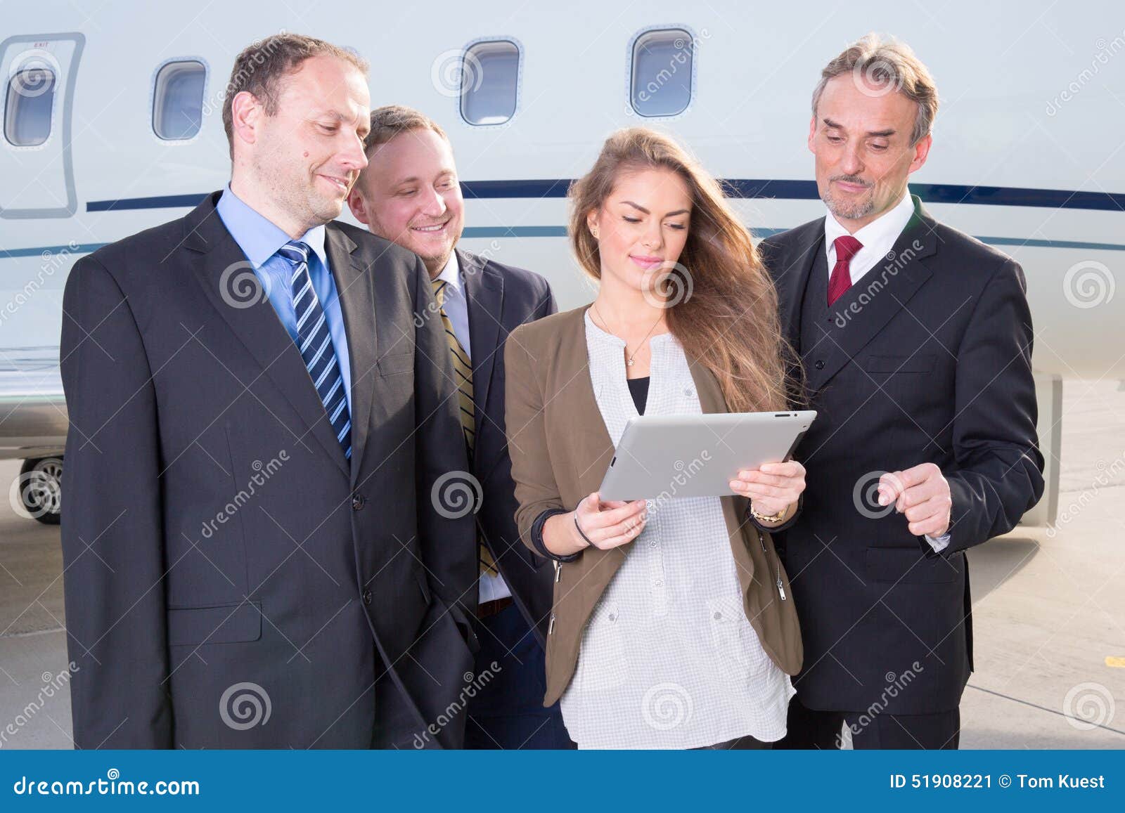 Business Team in Front of Corporate Jet Looking at Tablet Comput Stock ...