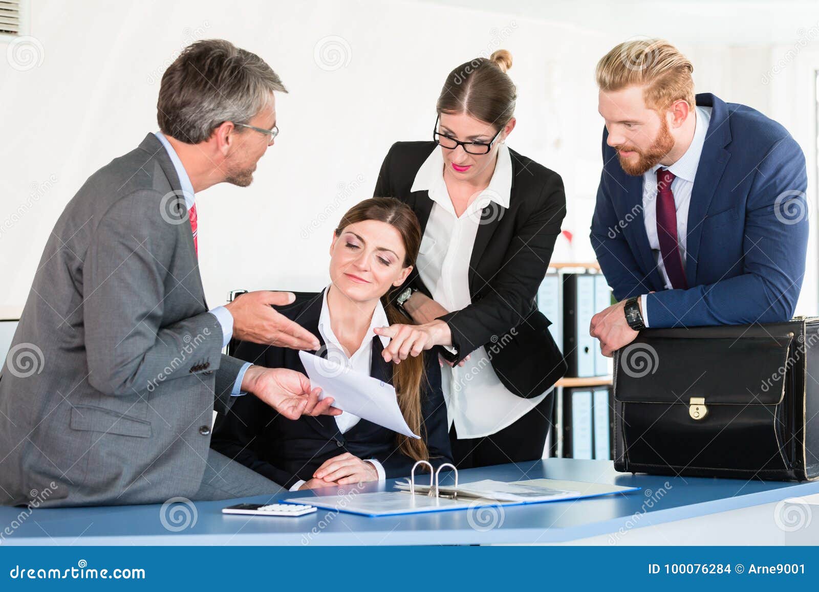 Team Gathers Around a Desk, Discussing a Document Stock Photo - Image ...