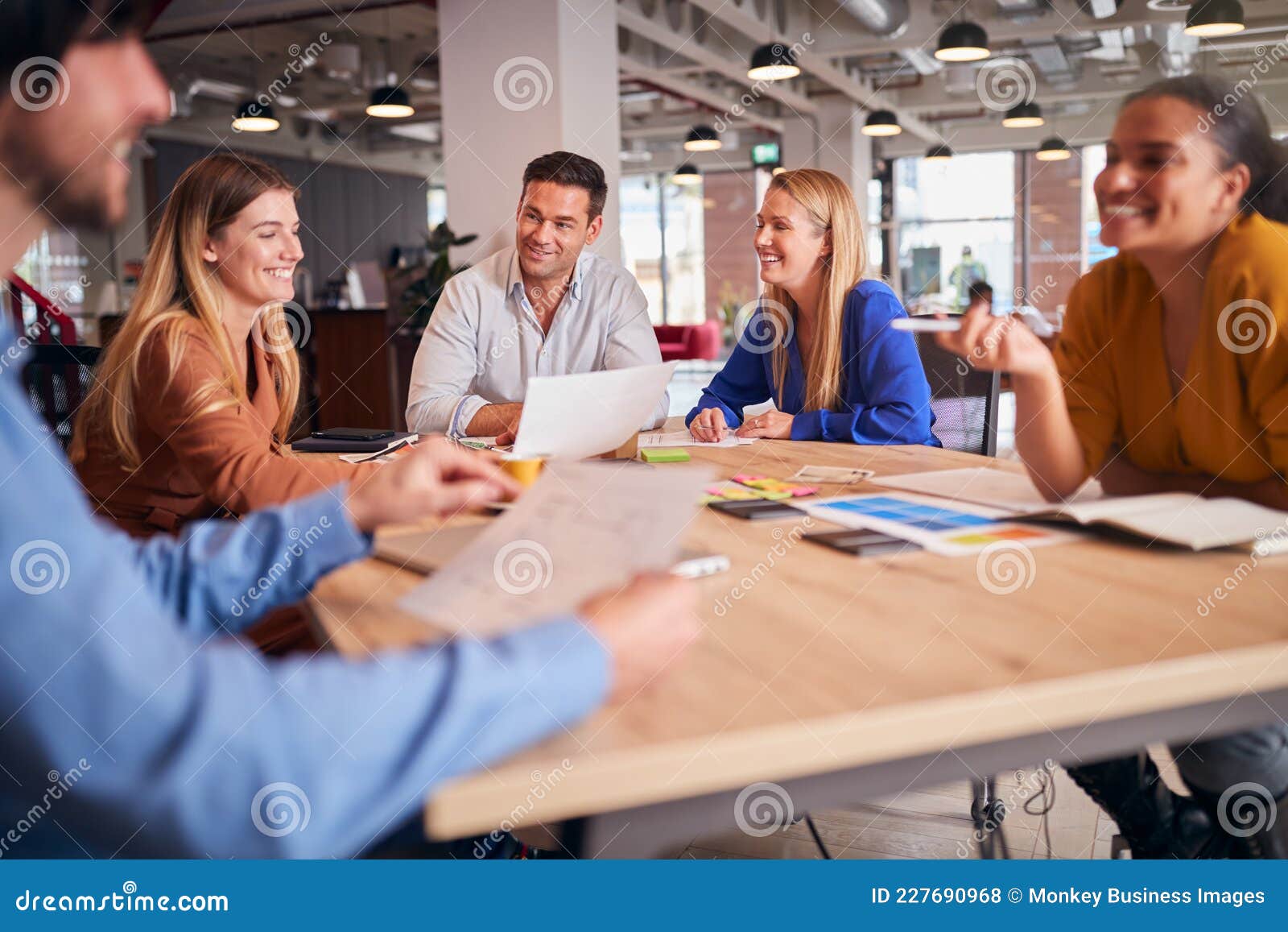 Business Team Having Meeting Sitting Around Table in Modern Open Plan ...