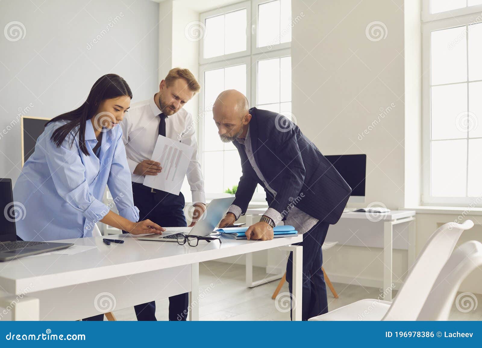 Business Team Looking at Laptop Screen Analyzing Research Data while ...