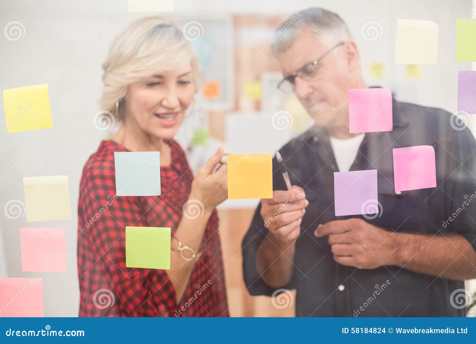 Business Team Pointing Post Its on the Wall Stock Photo - Image of ...