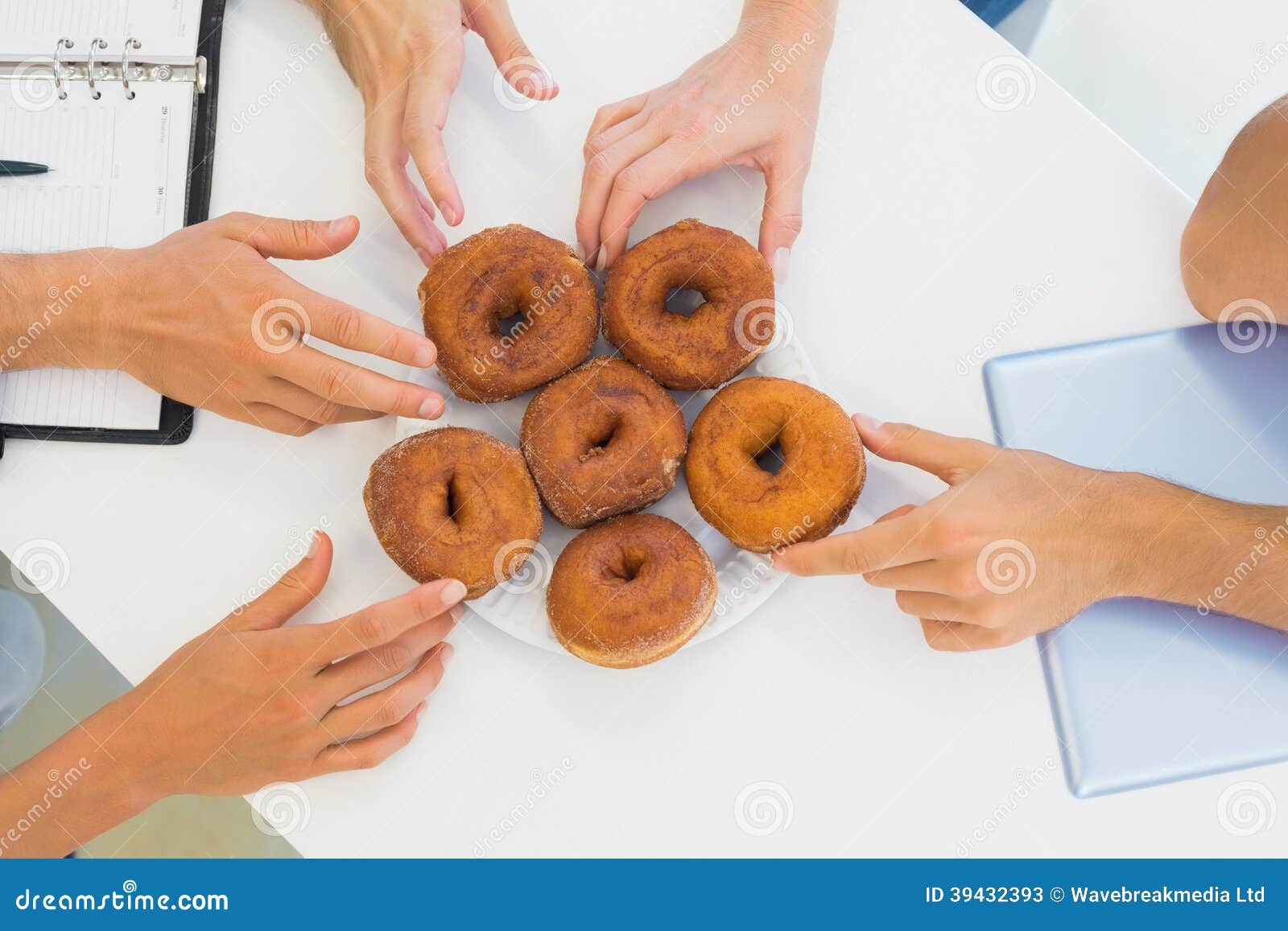 Business Team Reaching for Doughnuts on Table Stock Image - Image of ...
