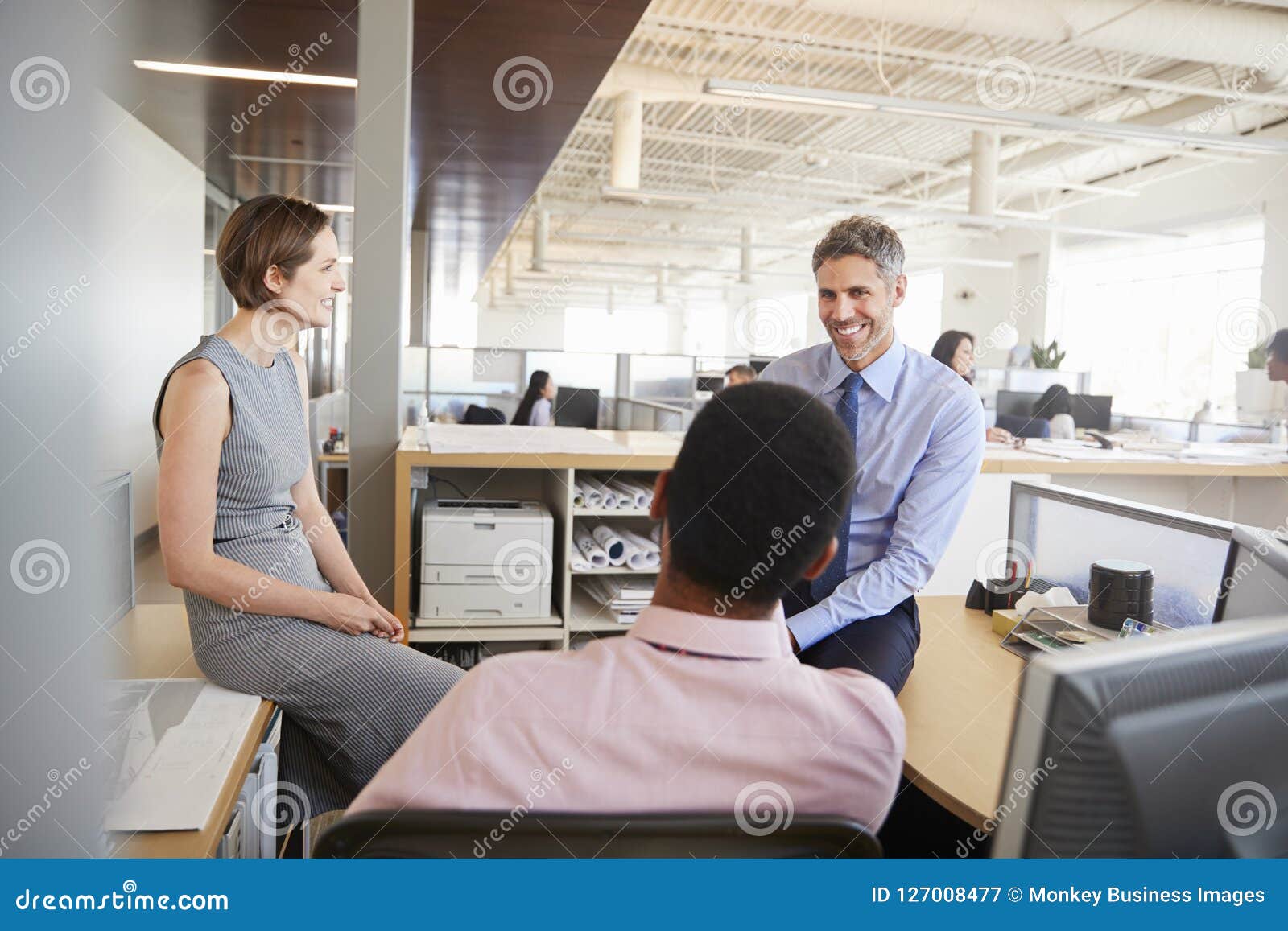 Business Team Talking at a Colleagues Workstation Stock Image - Image ...