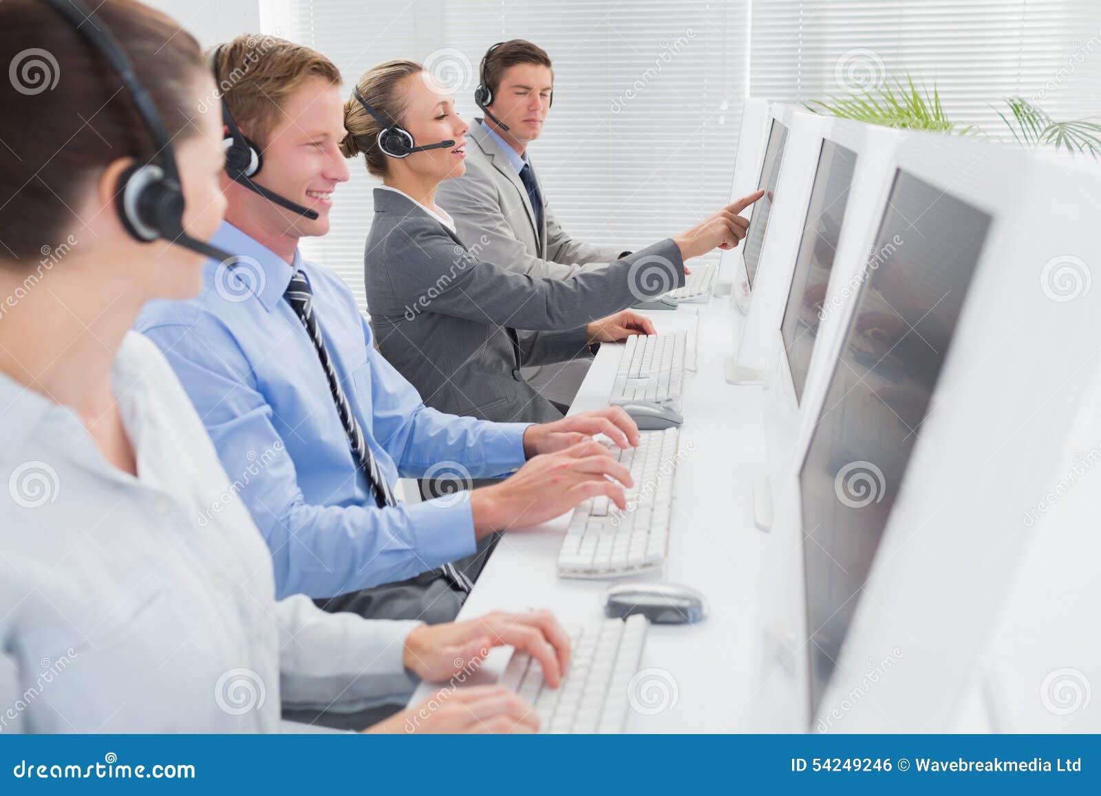 Business Team Working on Computers and Wearing Headsets Stock Photo ...