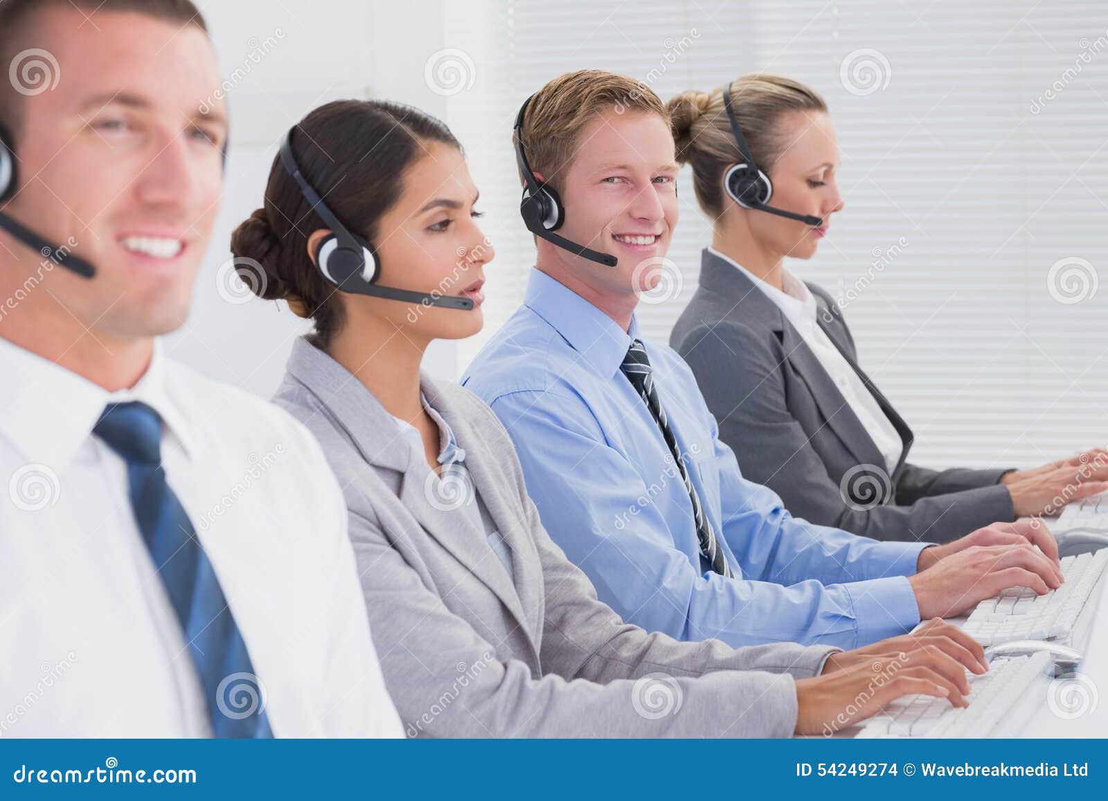 Business Team Working on Computers and Wearing Headsets Stock Photo ...