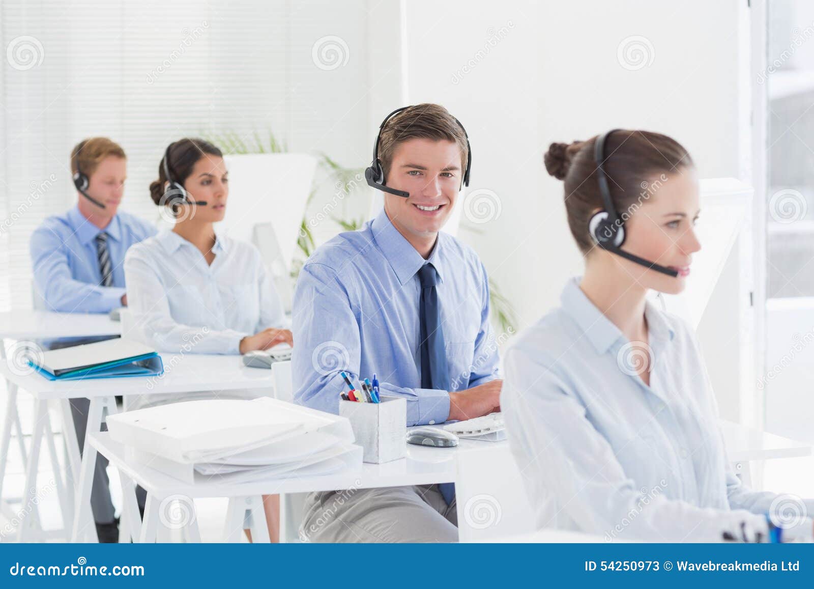 Business Team Working on Computers and Wearing Headsets Stock Image ...