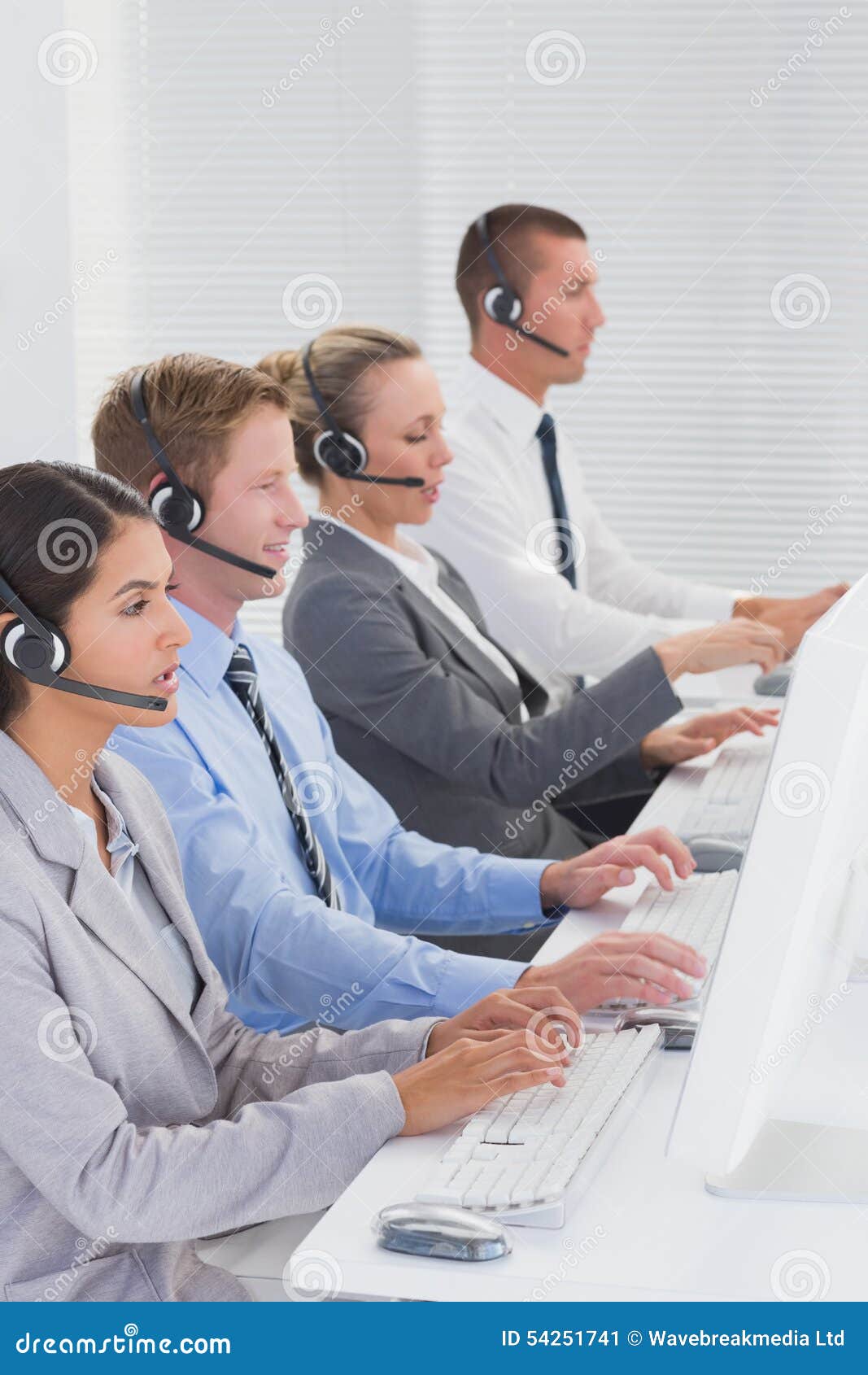 Business Team Working on Computers and Wearing Headsets Stock Image ...